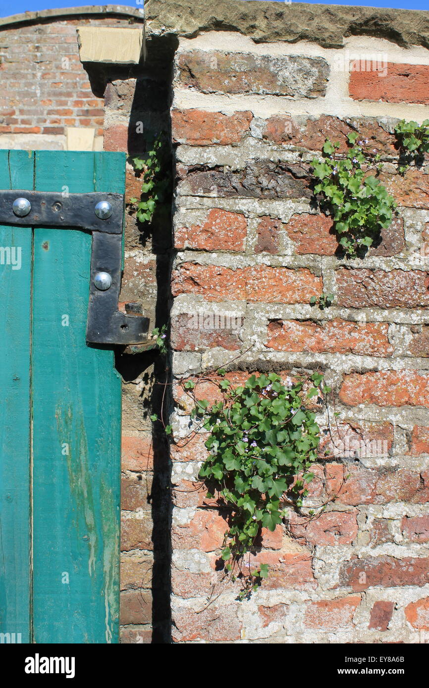 Old rusty gate hinge and red brick wall at Burton Agnes Hall, East ...