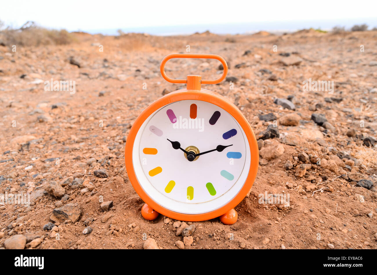 Classic Analog Clock In The Sand Stock Photo - Alamy