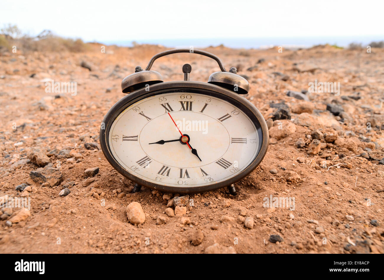 Classic Analog Clock In The Sand Stock Photo - Alamy
