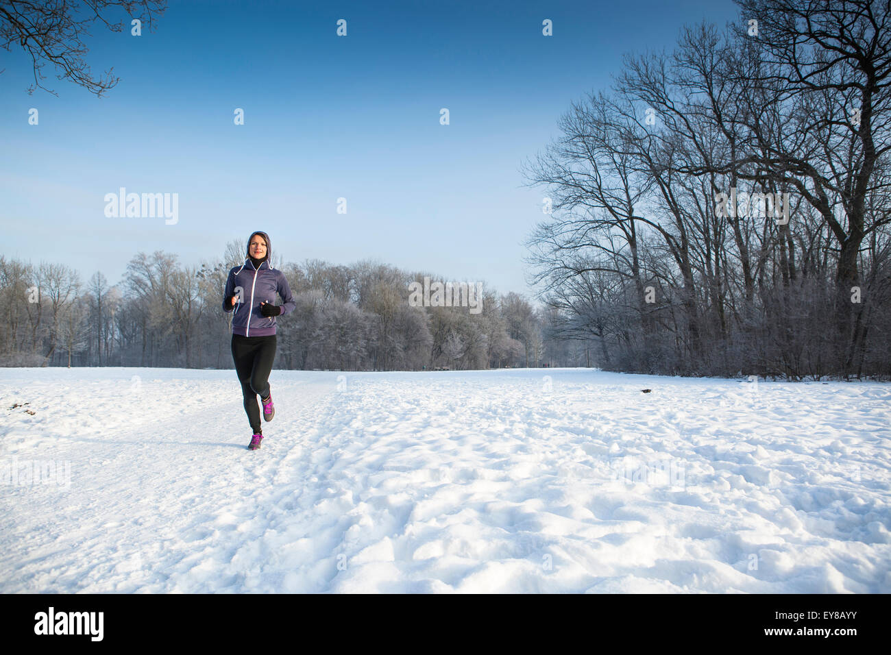 Young woman jogging in winter landscape Stock Photo - Alamy