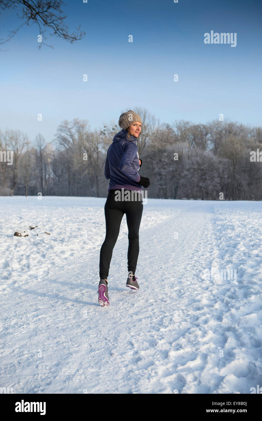 Young woman jogging in winter landscape Stock Photo - Alamy