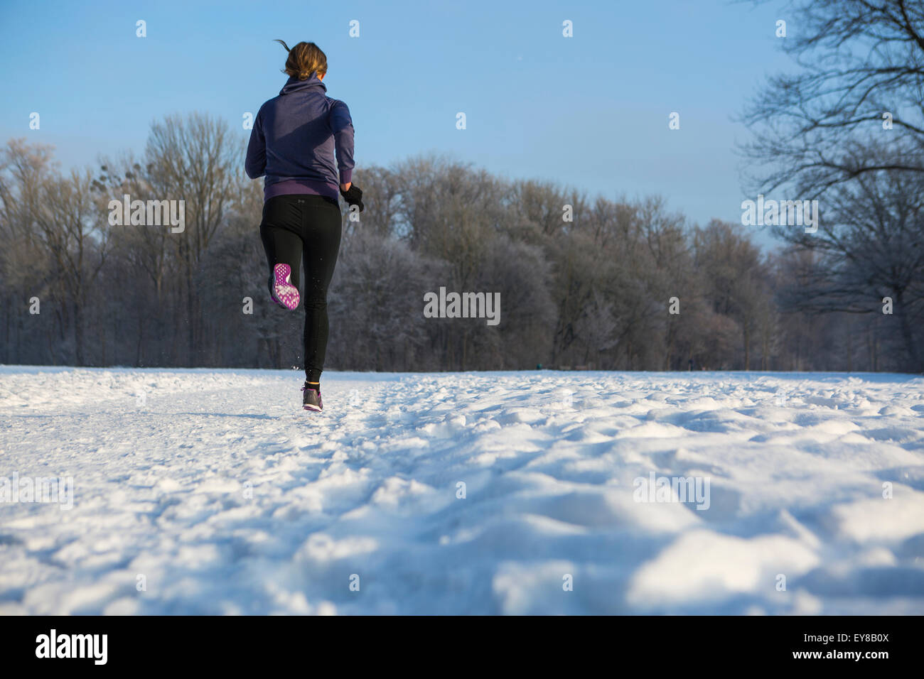 Young woman jogging in winter landscape Stock Photo - Alamy