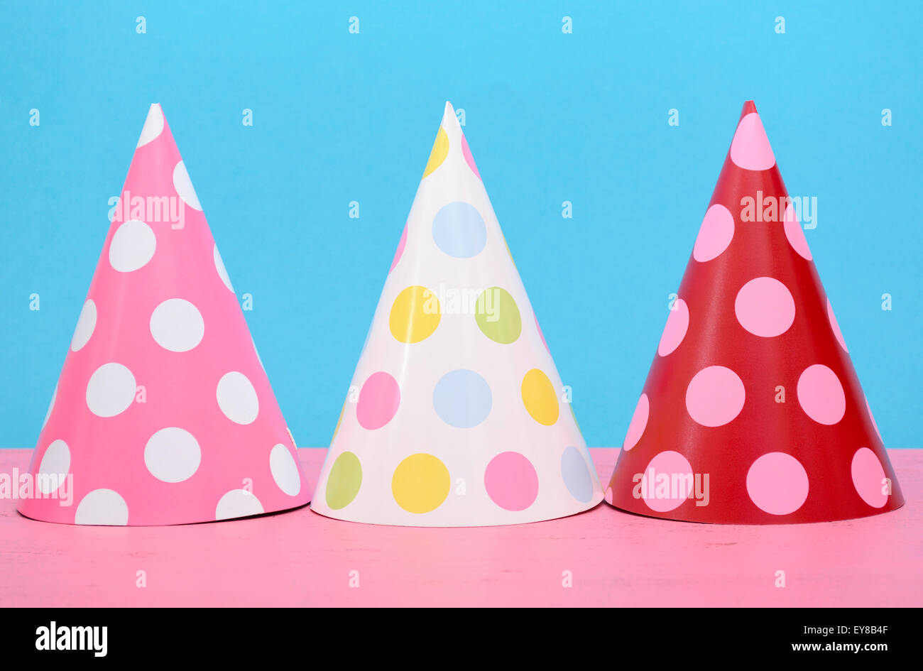 Bright party polka dot party hats on modern pink and blue background ...
