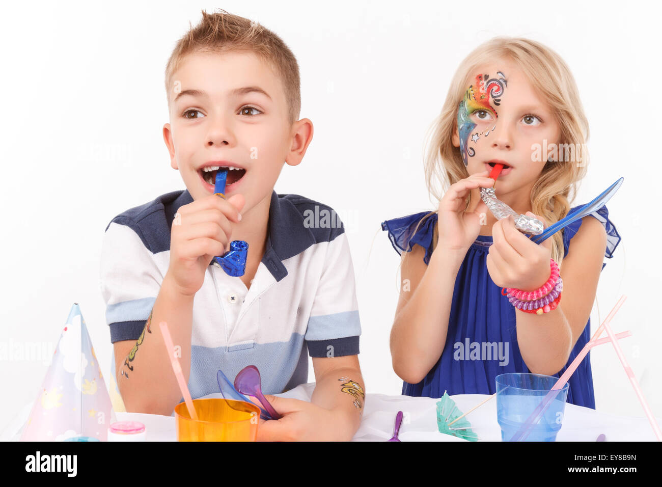 Pleasant children blowing birthday pipes Stock Photo - Alamy