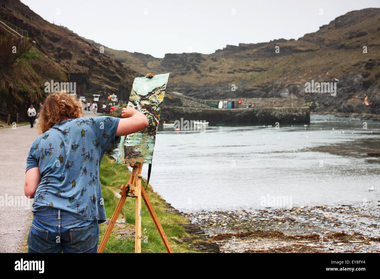 An artist painting a picture outside using an easel to support the ...