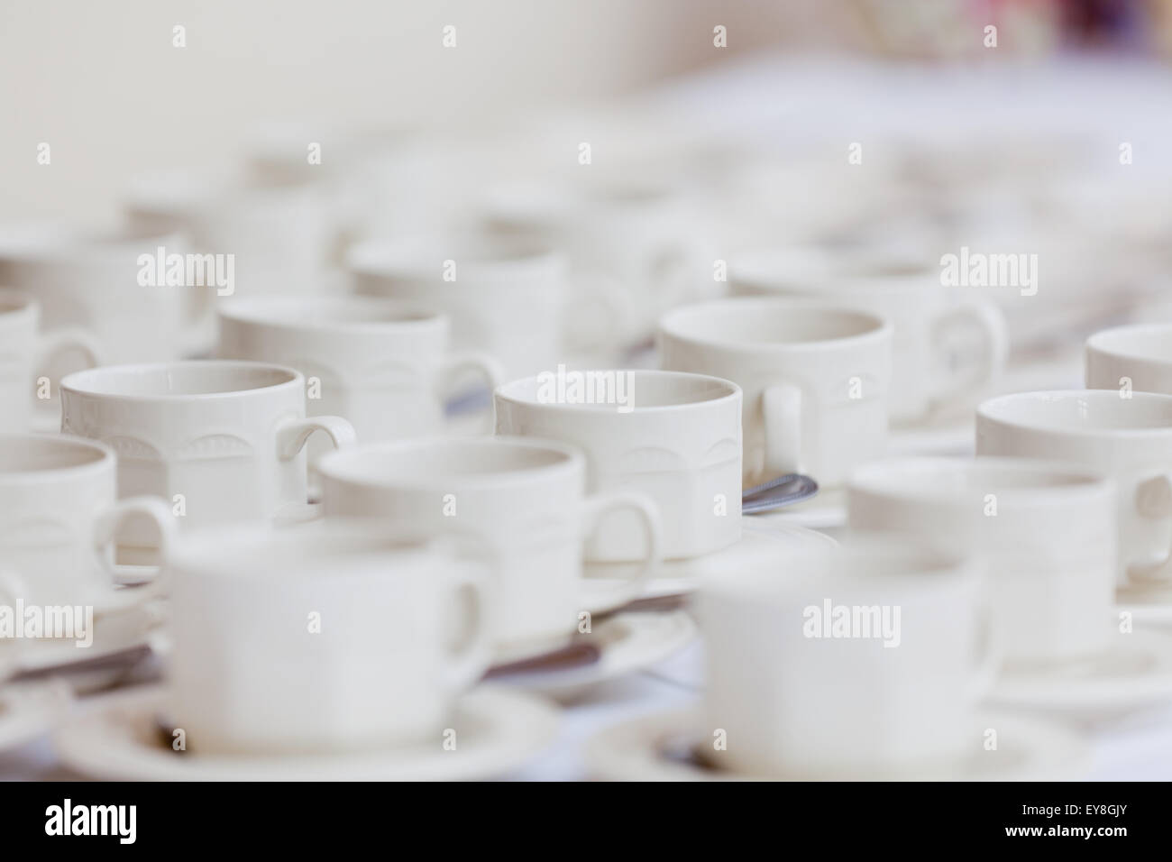 Numerous rows of empty coffee or tea cups and saucers arranged on a ...