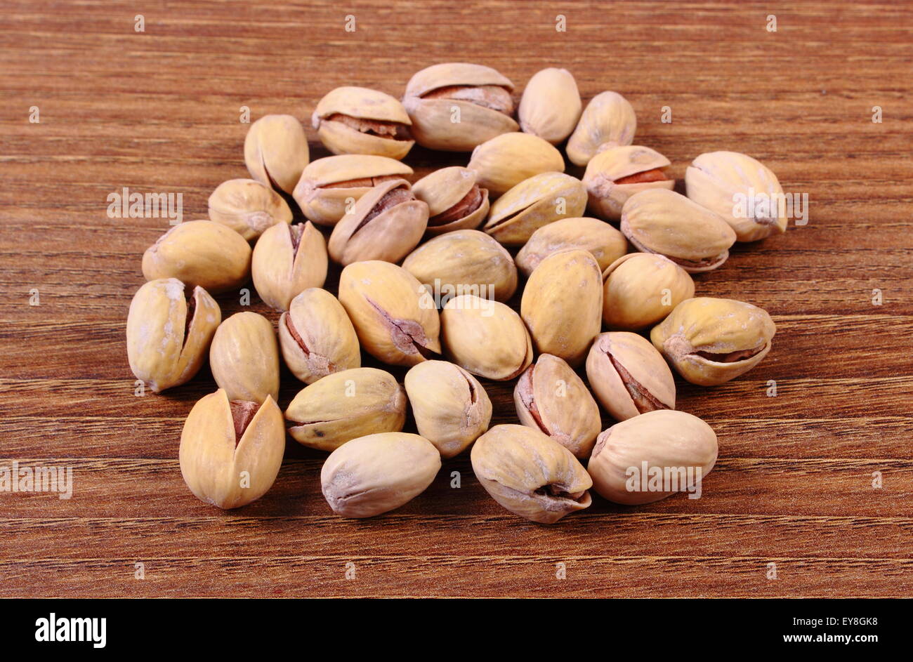 Roasted pistachio nuts on natural wooden table background, healthy food and nutrition Stock ...