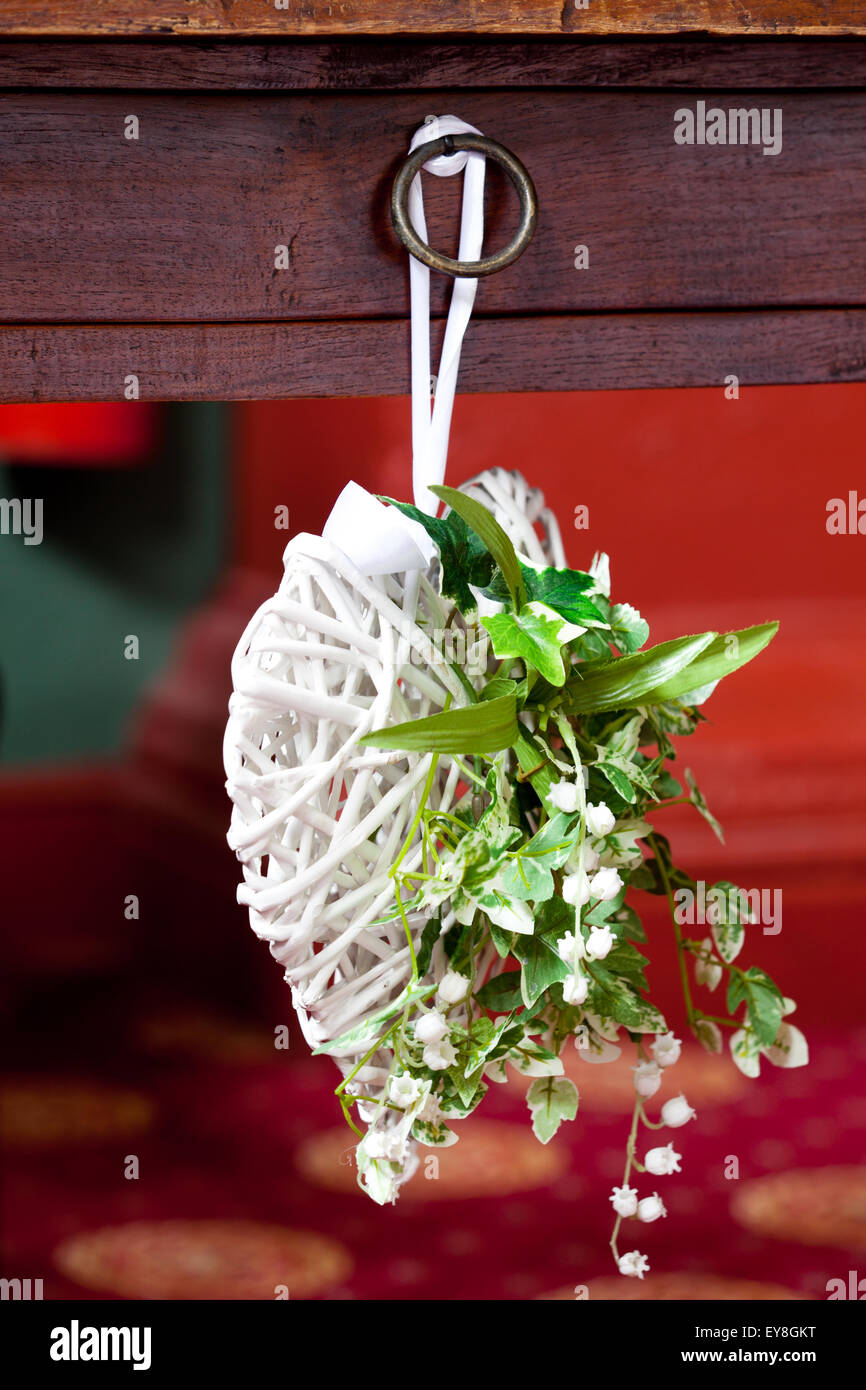 A woven heart decoration, hung from a table as part of the wedding ...