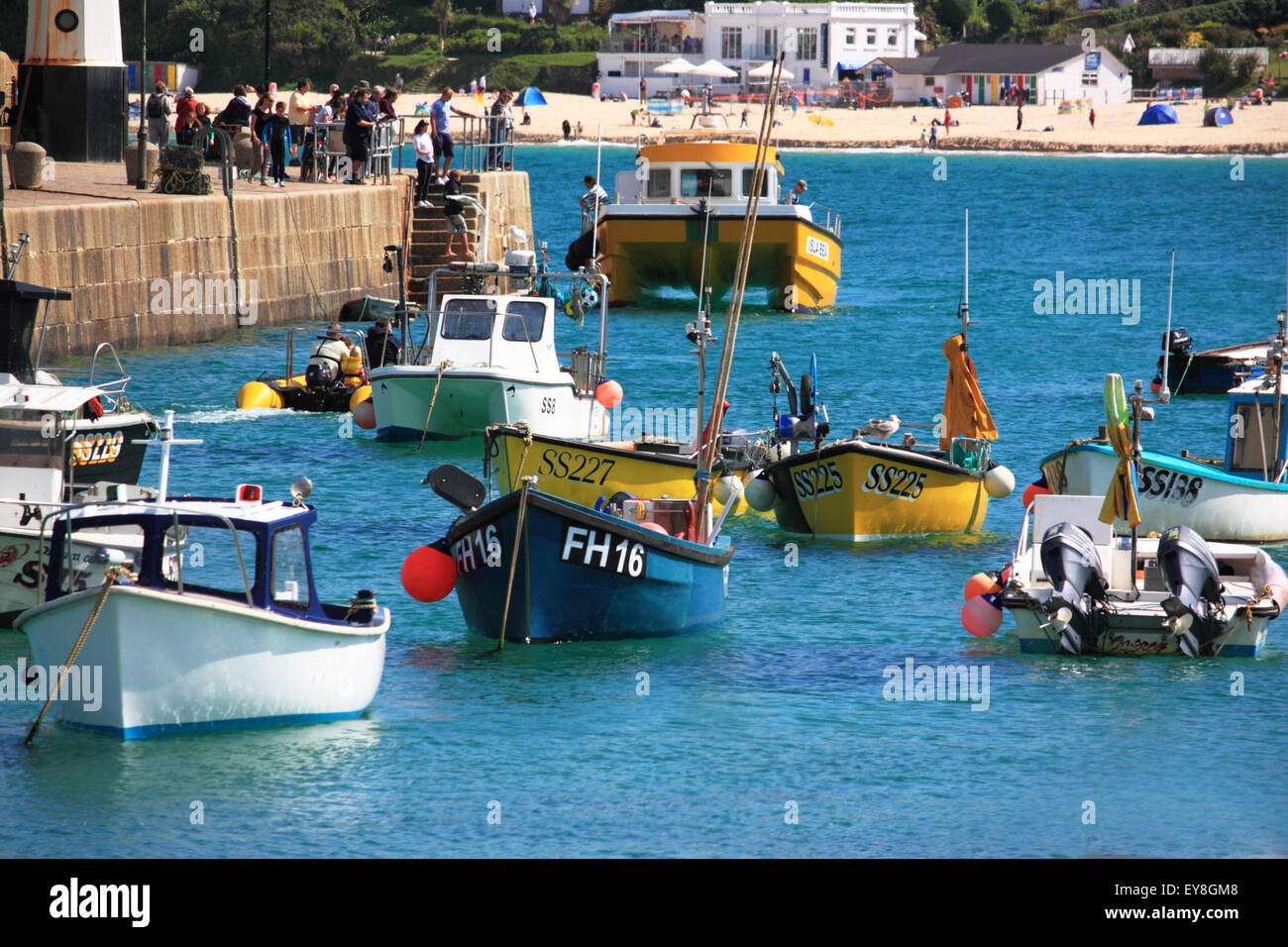 Boats moored on blue sea at a Cornish harbour Stock Photo - Alamy