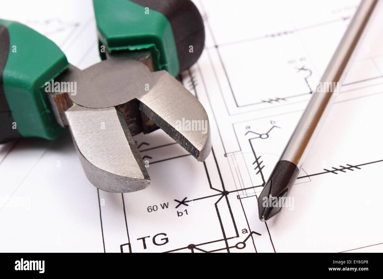 Metal pliers and screwdriver on electrical construction drawing of ...