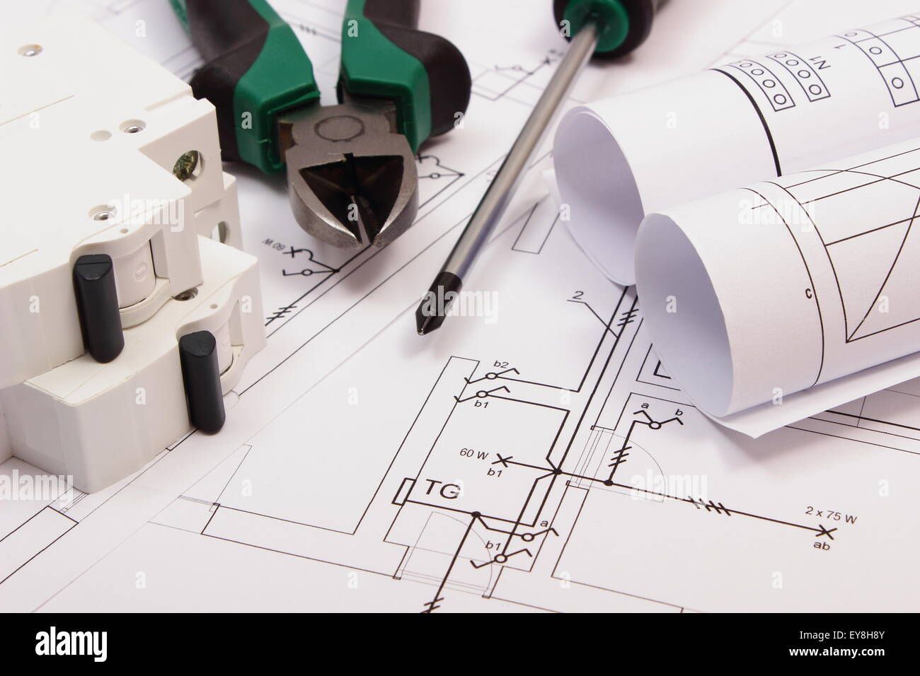 Metal pliers, screwdriver, electric fuse and rolls of diagrams on ...