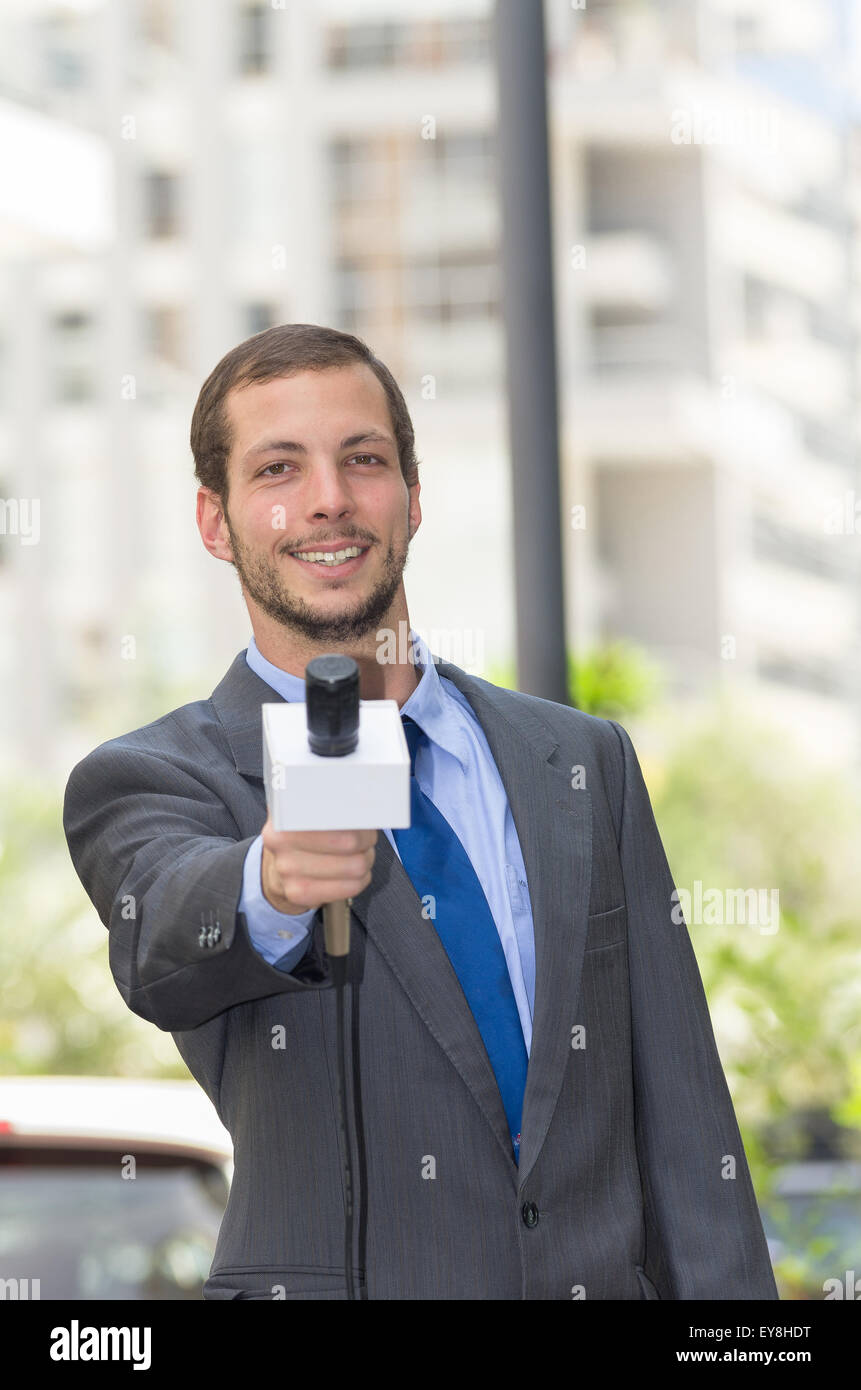 Attractive professional male news reporter wearing grey suit holding ...
