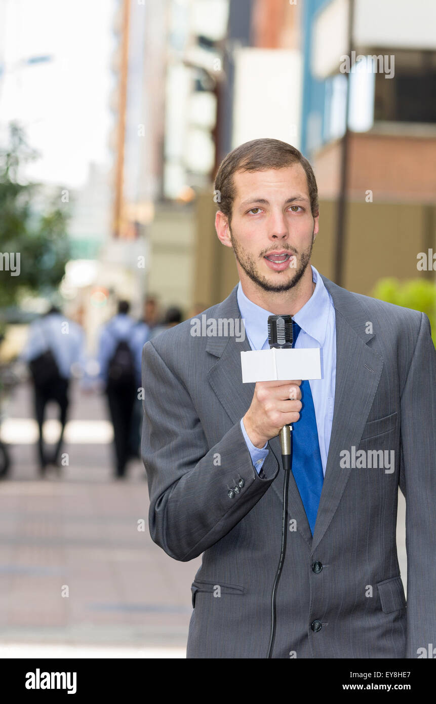 Attractive professional male news reporter wearing grey suit holding ...
