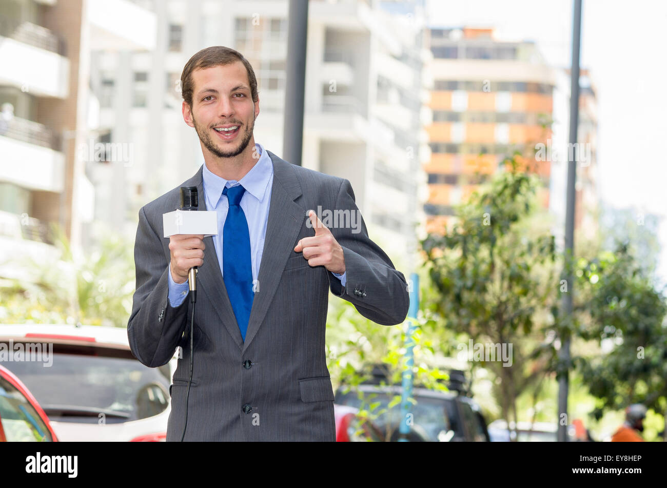 Attractive professional male news reporter wearing grey suit holding ...