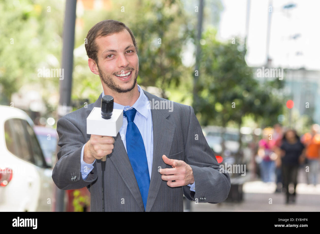 Attractive professional male news reporter wearing grey suit holding ...