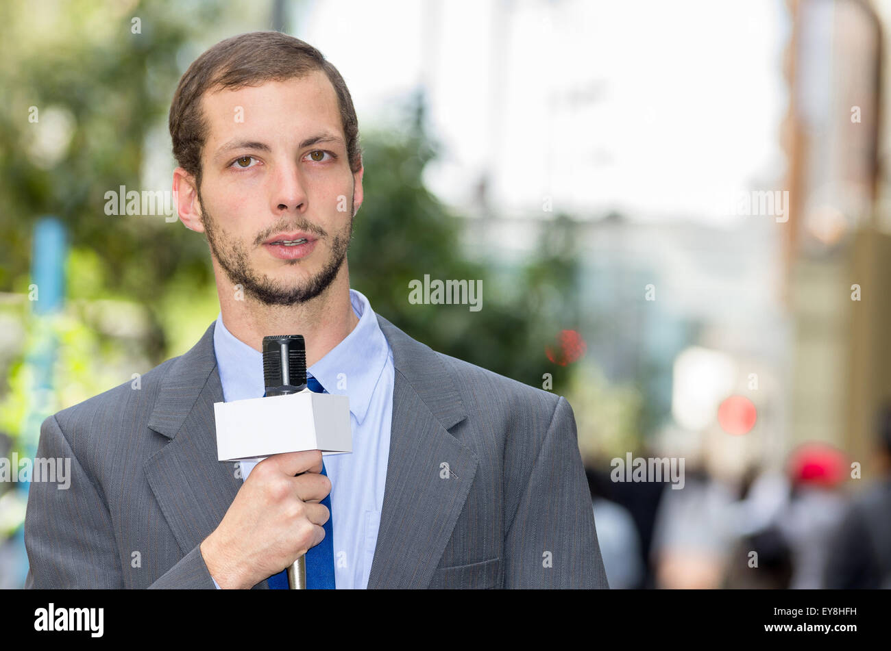Attractive professional male news reporter wearing grey suit holding ...