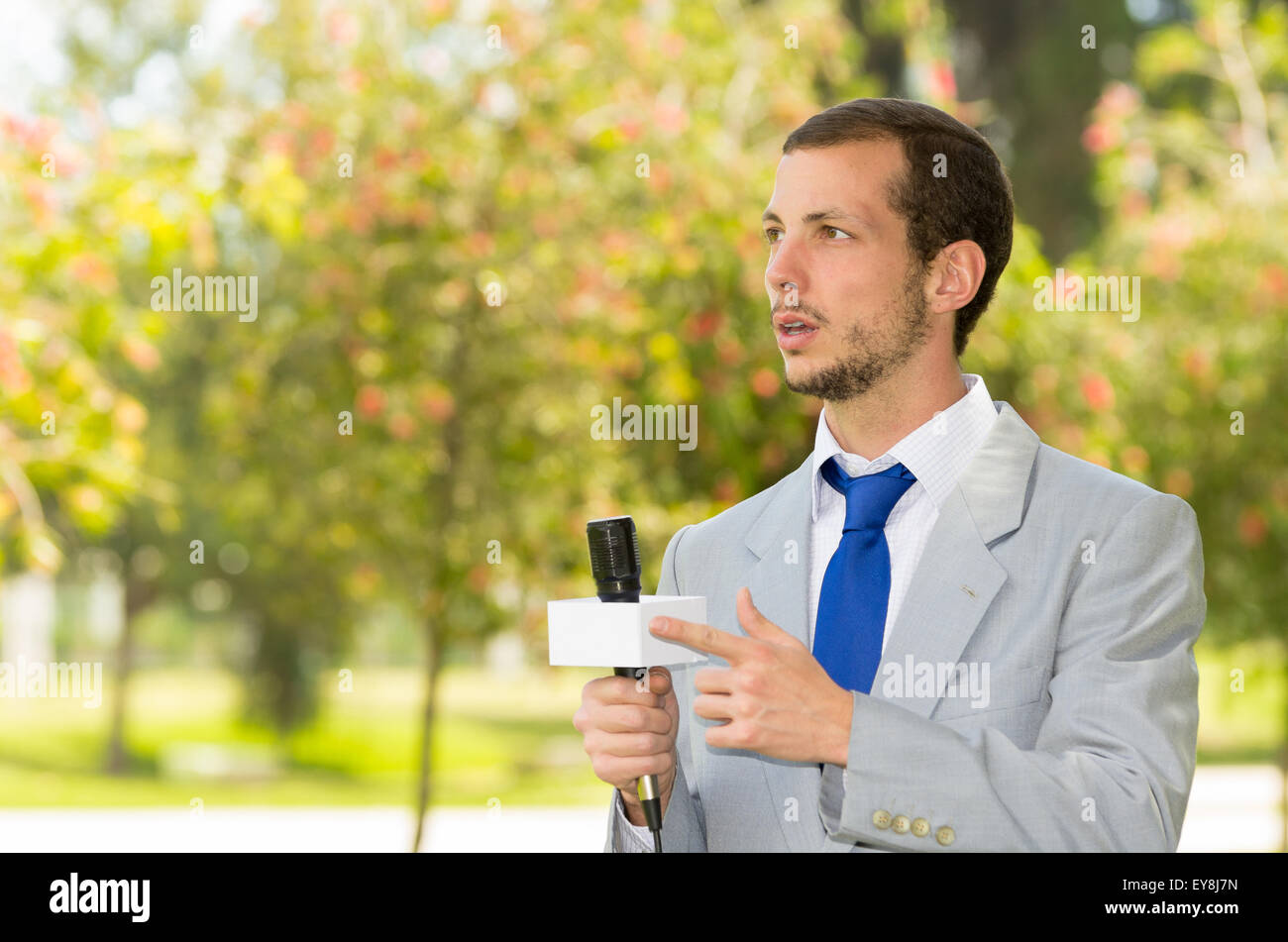 Successful handsome male news reporter wearing light grey suit working ...