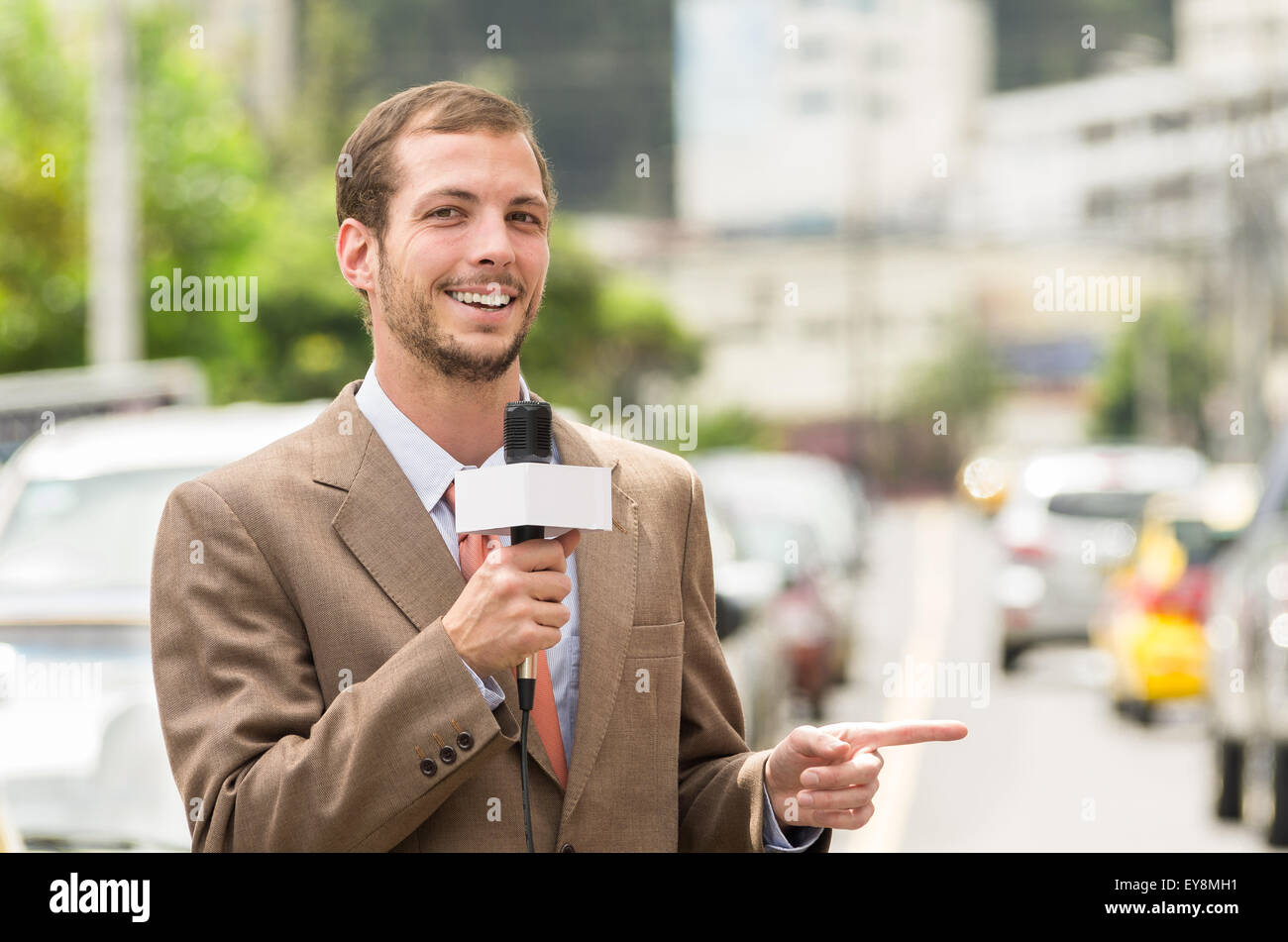 Successful attractive male journalist wearing brown suit working ...