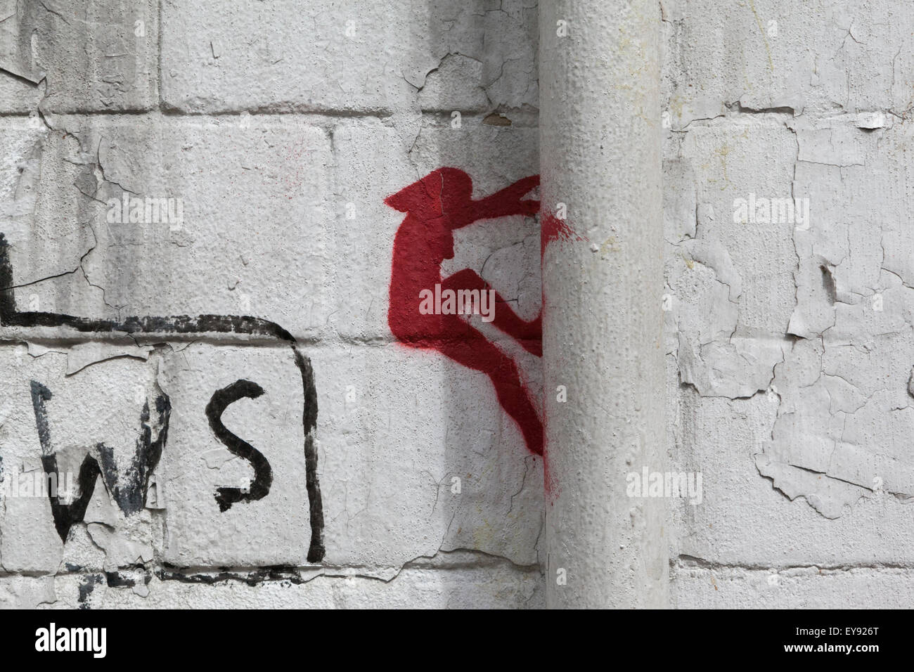 Stenciled artwork depicting a red female climbing up a drain pipe Stock ...