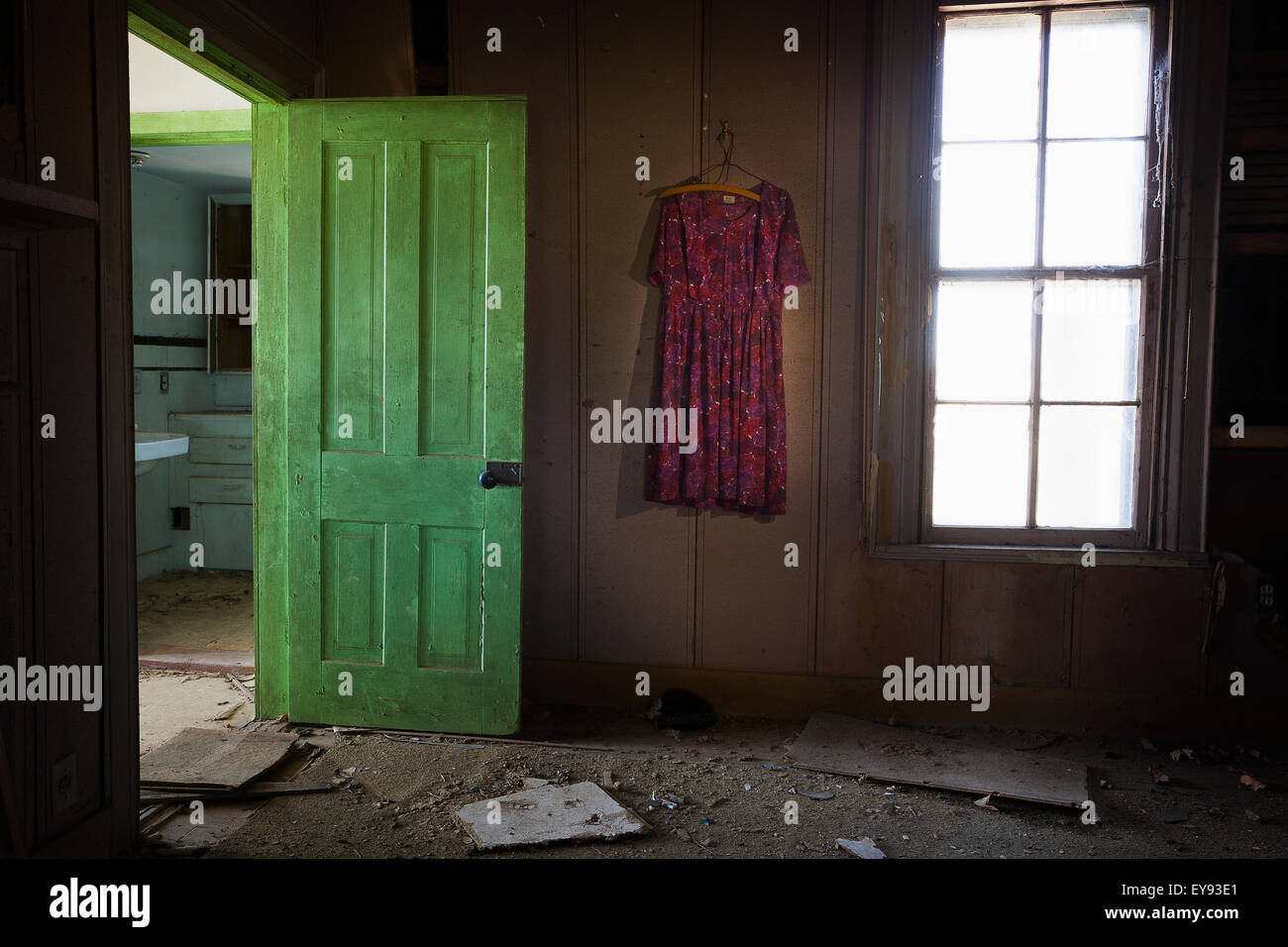 Room inside an old abandoned house with a green door open and an old ...