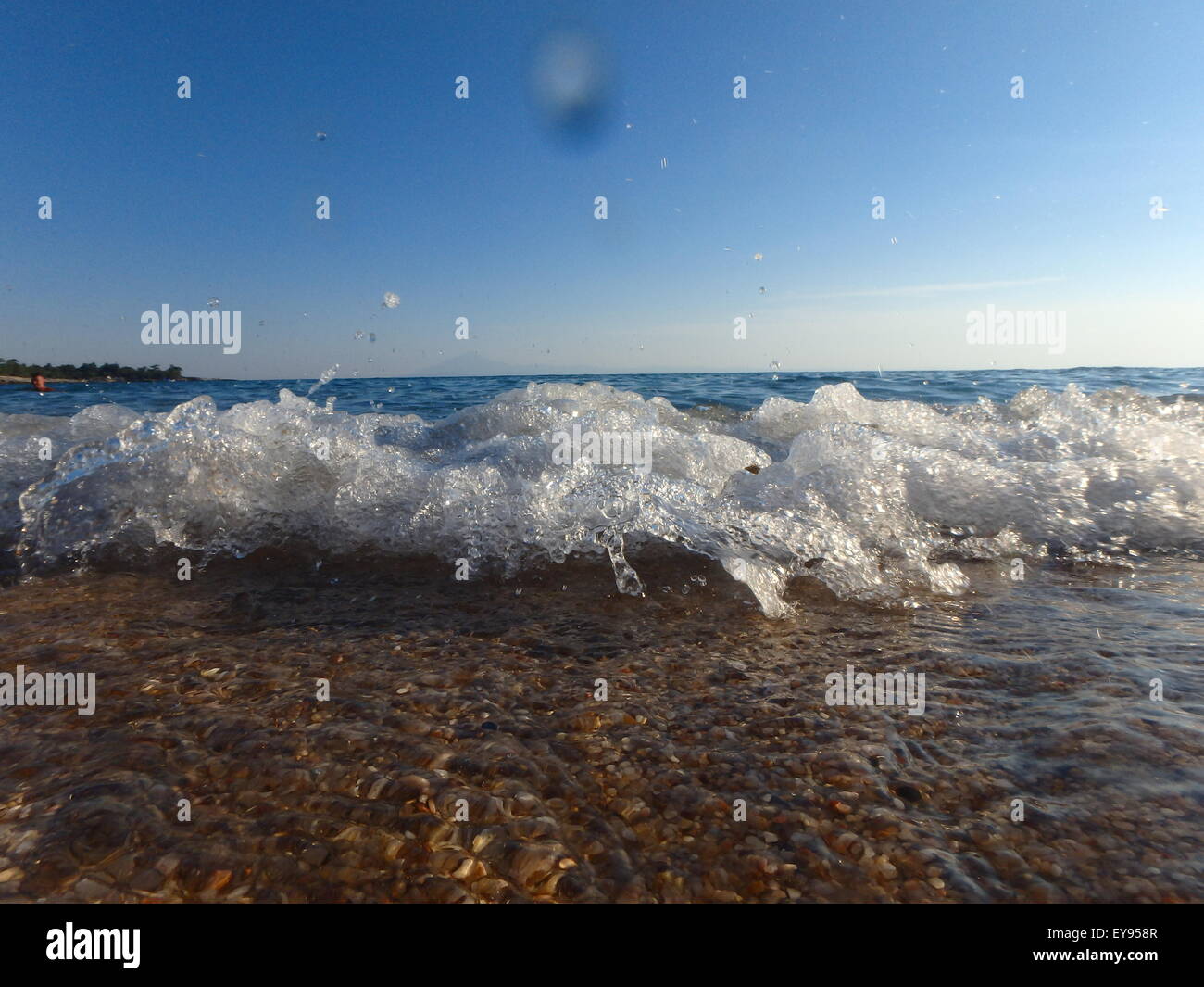 Small waves splashing in shallow waters at sunset Stock Photo - Alamy