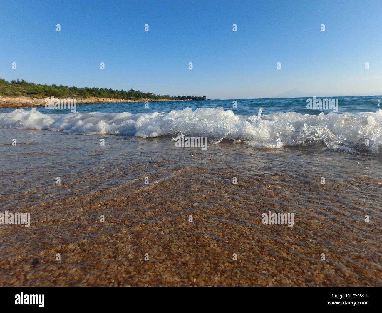 Small waves splashing in shallow waters at sunset Stock Photo - Alamy
