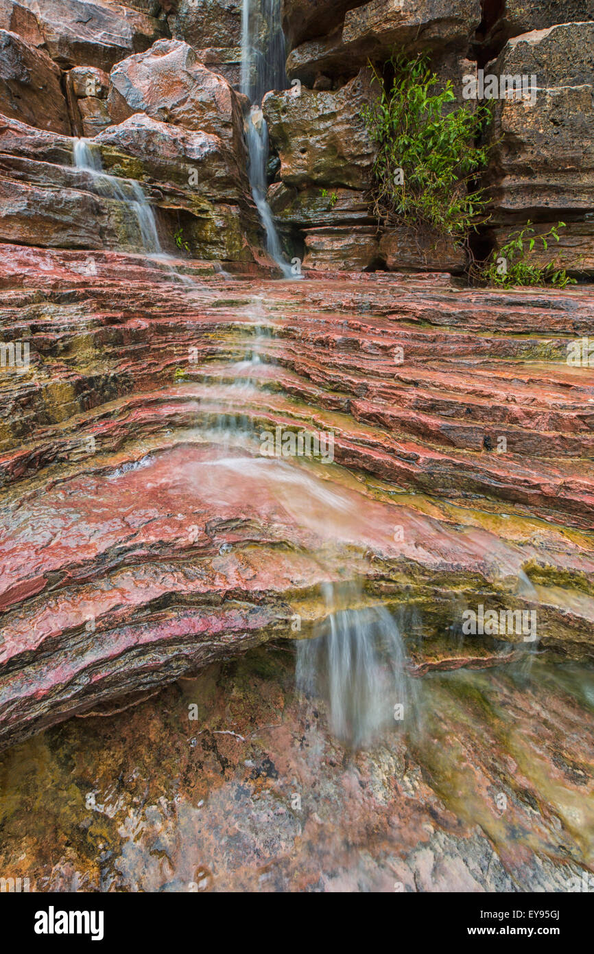 Water flows over a very colourful waterfall in the heart of Toro Toro ...