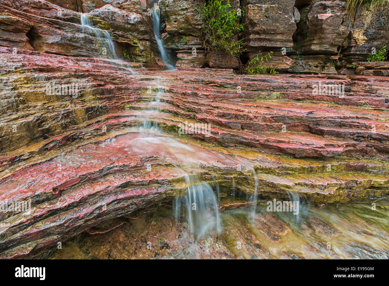 Water flows over a very colourful waterfall in the heart of Toro Toro ...