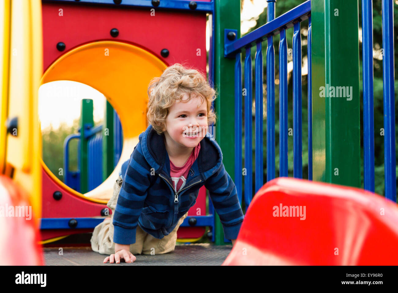 Toddler boy playing at a city playground at sunset; St. Albert, Alberta ...
