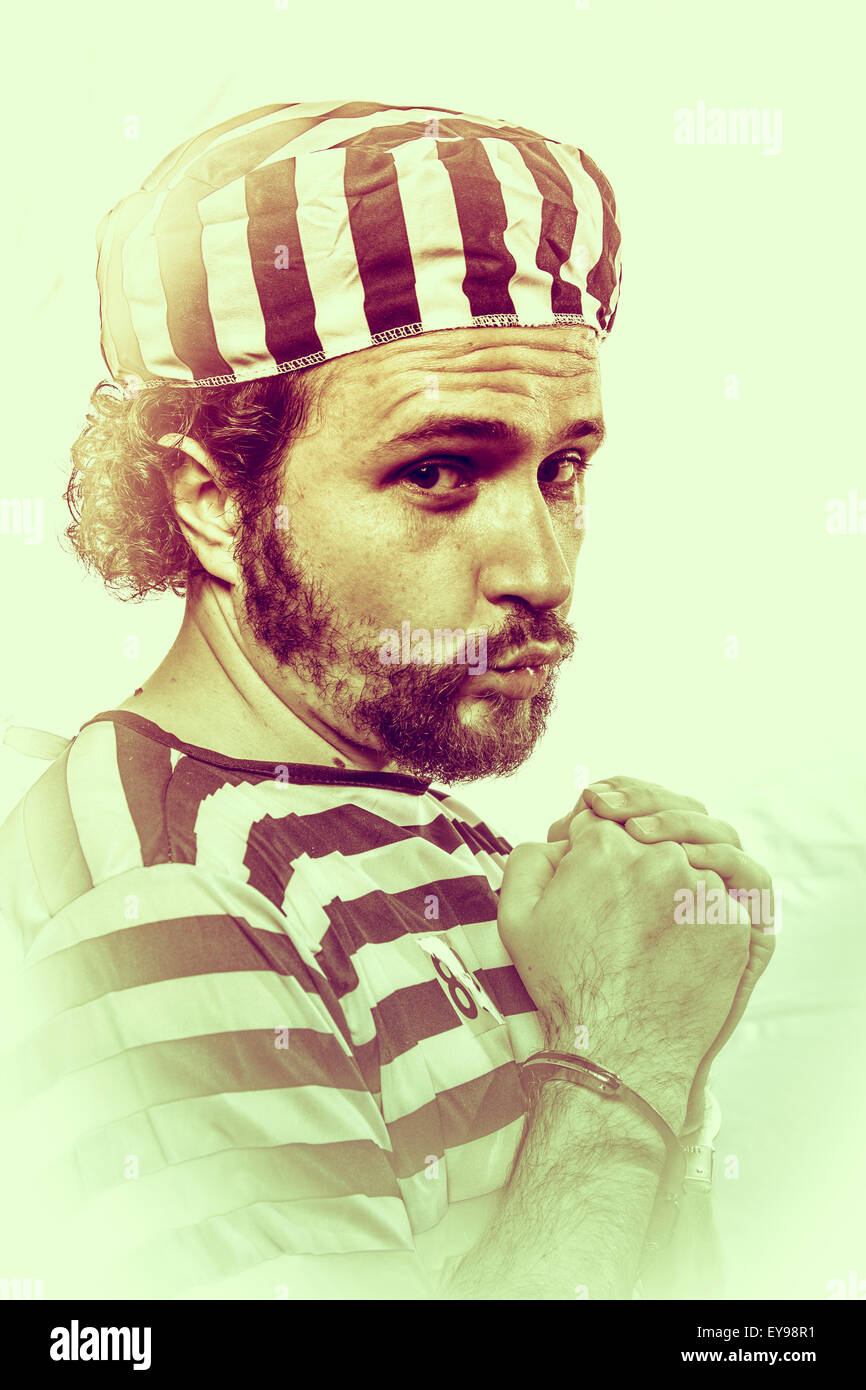 Locked, Desperate, portrait of a man prisoner in prison garb, over ...