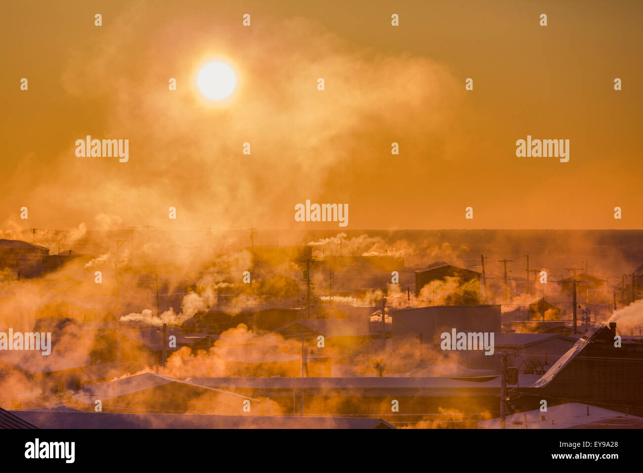 Billowing chimneys of downtown Barrow are silhouetted by the setting ...