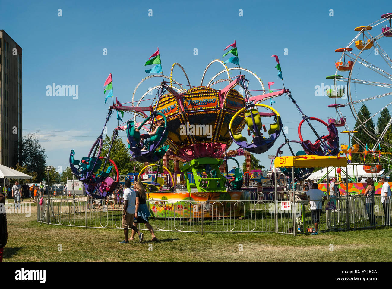 A carnival style ride that spins and tilts the riders in chairs hung ...