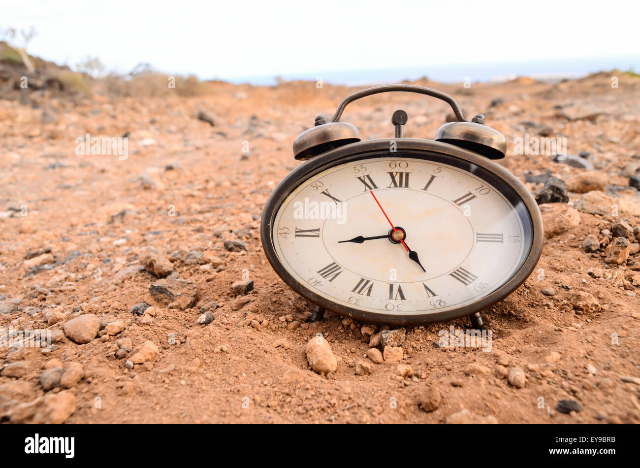 Classic Analog Clock In The Sand Stock Photo - Alamy