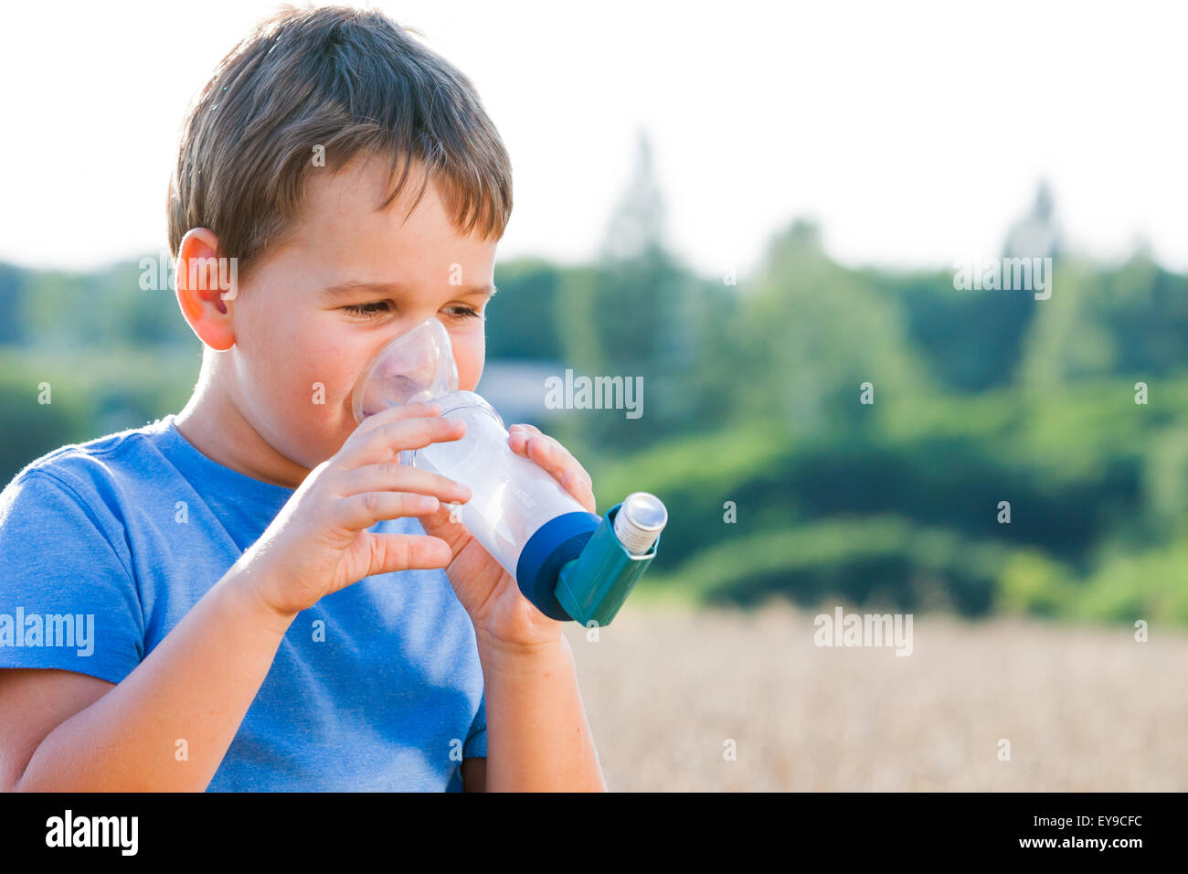 Boy using inhaler for asthma in village with summer sunset Stock Photo ...