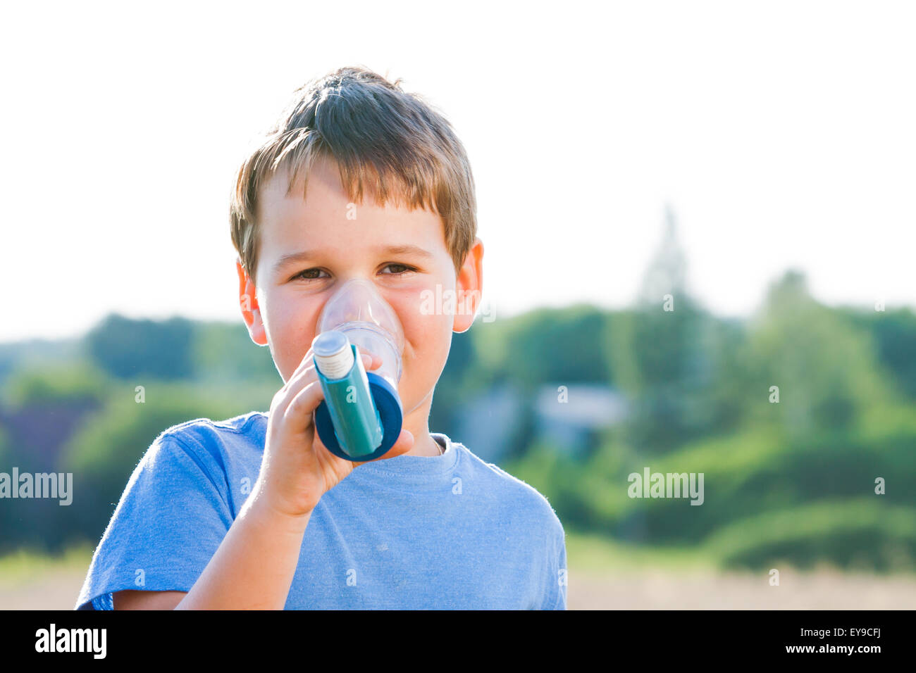 Boy using inhaler for asthma in village with summer sunset Stock Photo ...