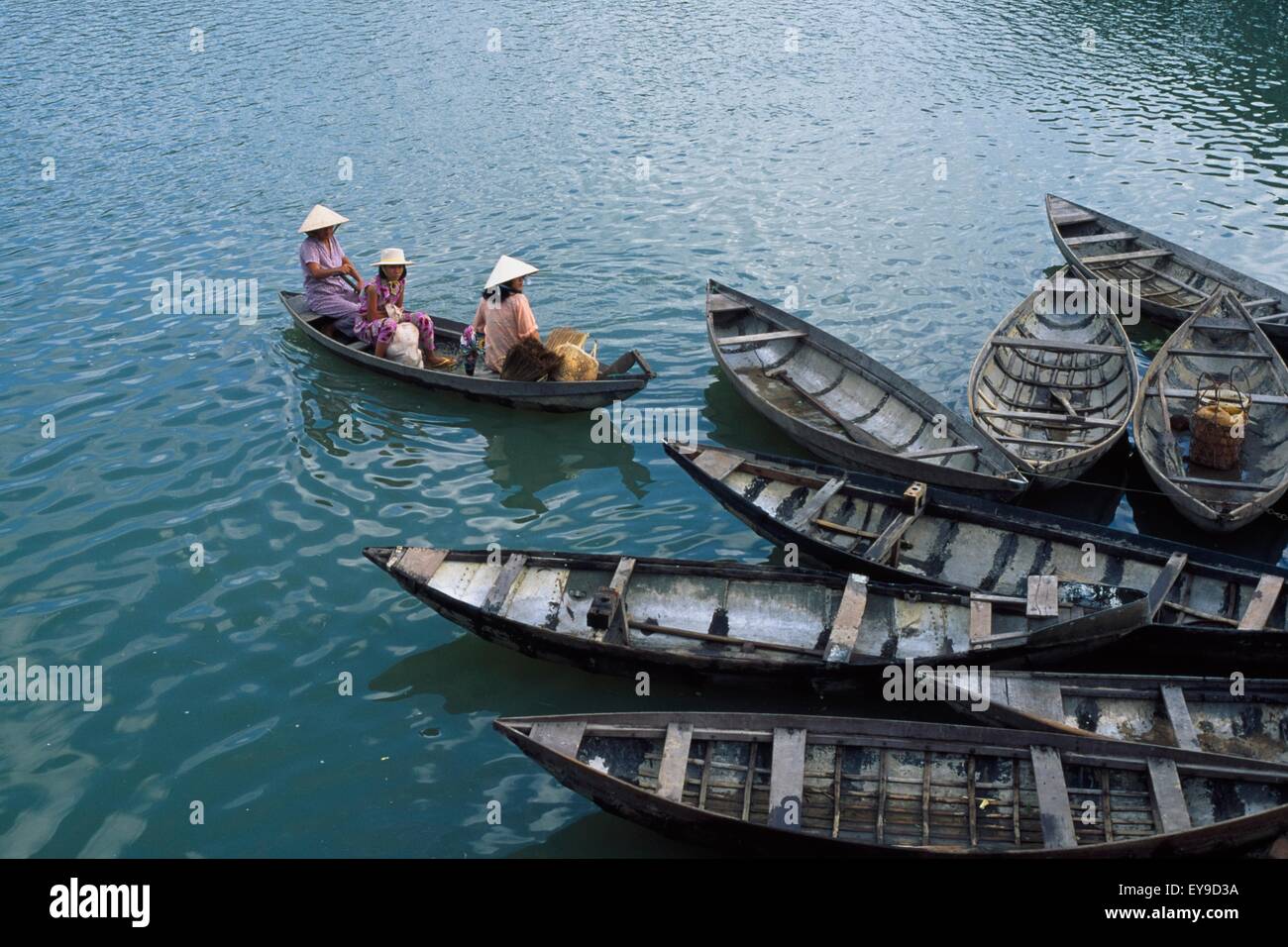 Three Women In Boat Wearing Conical Hats Stock Photo - Alamy