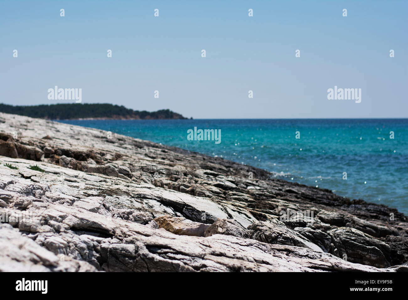 Rocks against the deep blue sea and waves Stock Photo - Alamy