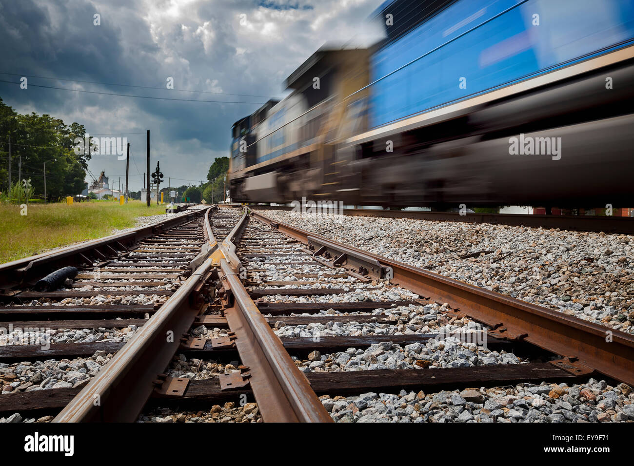 Train with blurred movement with converging rails in the foreground and ...