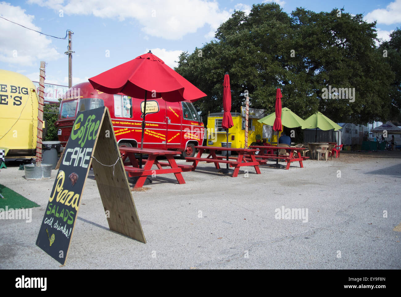 Various food trucks serving different cuisines line a parking lot ...