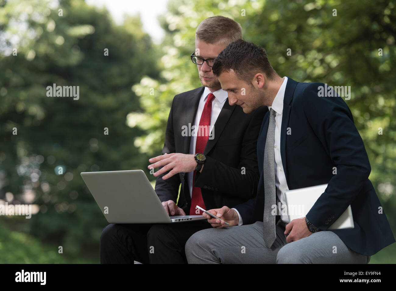 Happy Business Men Using Tablet Pc Outside On A Park Bench Stock Photo ...