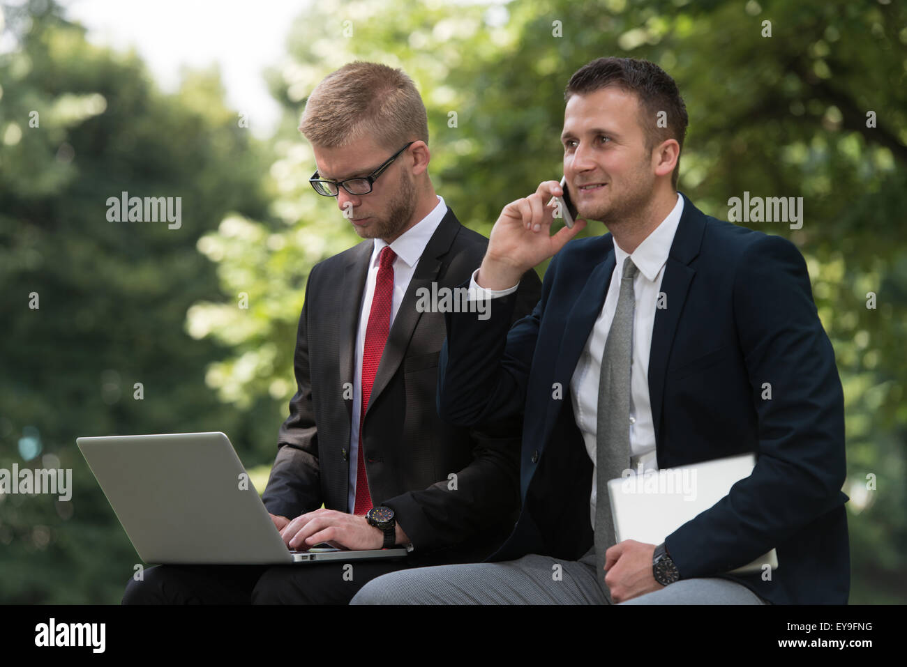 Happy Business Men Using Tablet Pc Outside On A Park Bench Stock Photo ...