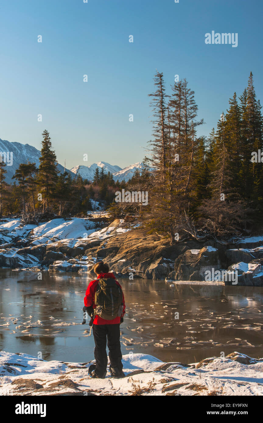 A man snowshoeing along the Cook Inlet with Kenai Mountains in the ...
