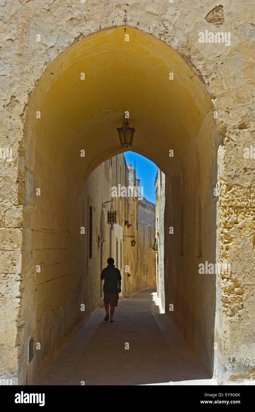 Person Walking Through Arched Passage Stock Photo - Alamy