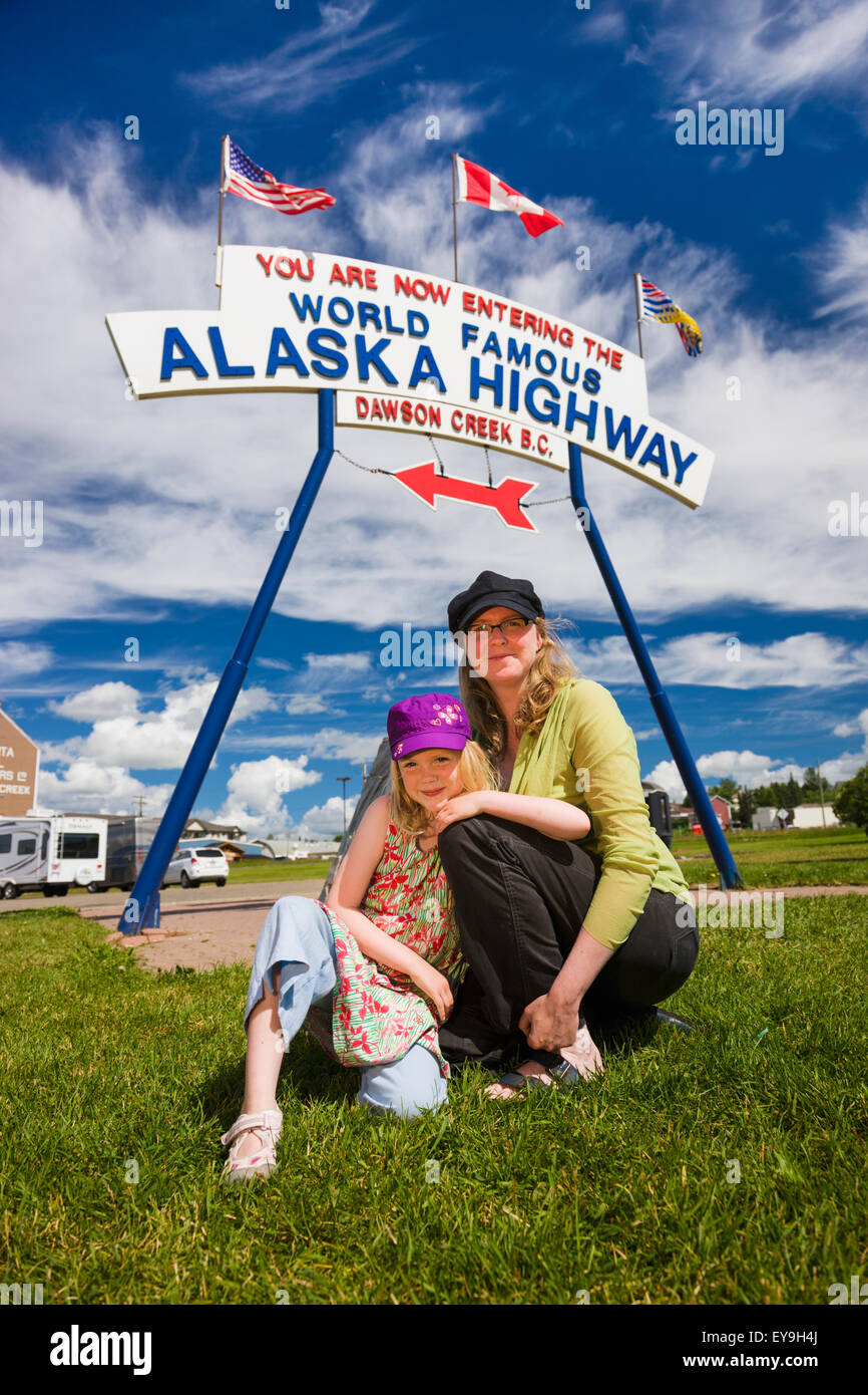 Young girl and mother pose under the World Famous Alaska Highway sign ...