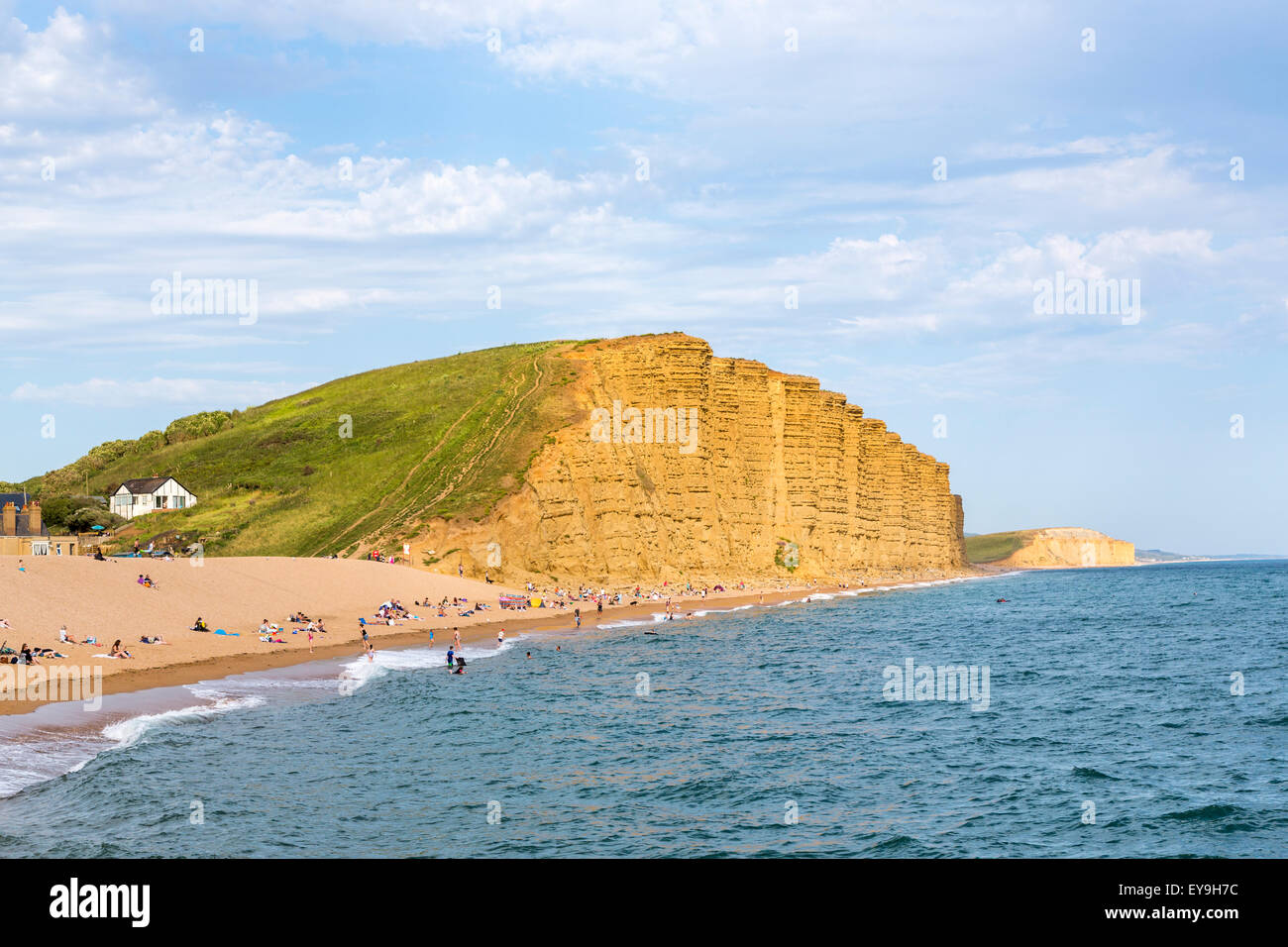 Sandy beach and tall golden yellow cliffs at West Bay on the Jurassic ...