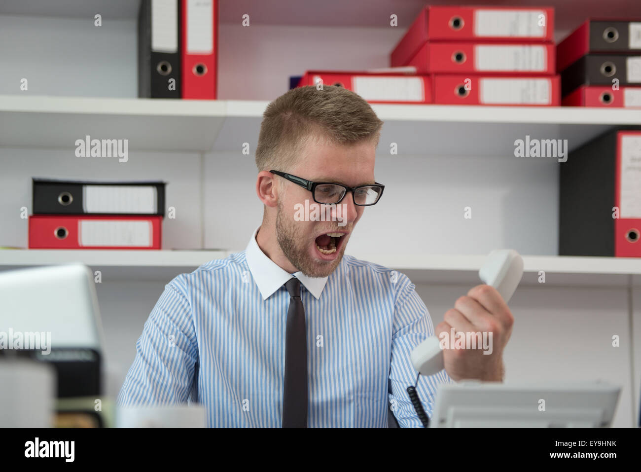 Angry Businessman Yelling Into A Phone Stock Photo - Alamy