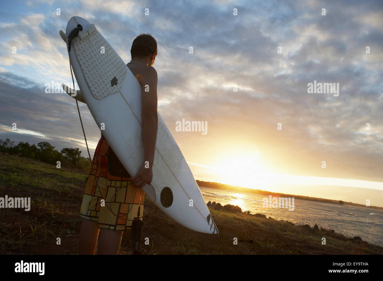 Man Holding Surfboard At Sunset Stock Photo - Alamy