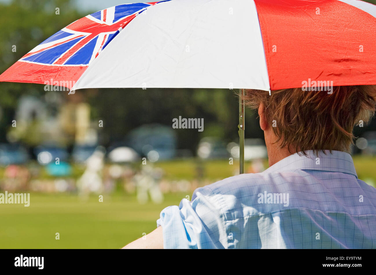 Rear View Of A Spectator With An Umbrella Watching A Cricket Match On A ...
