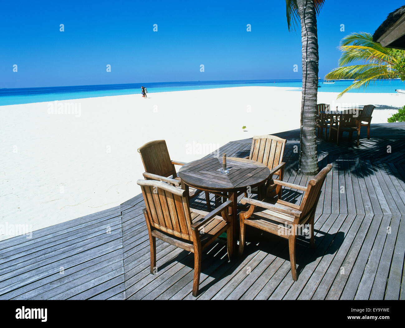 Chairs And Table On Deck By Beach Stock Photo - Alamy