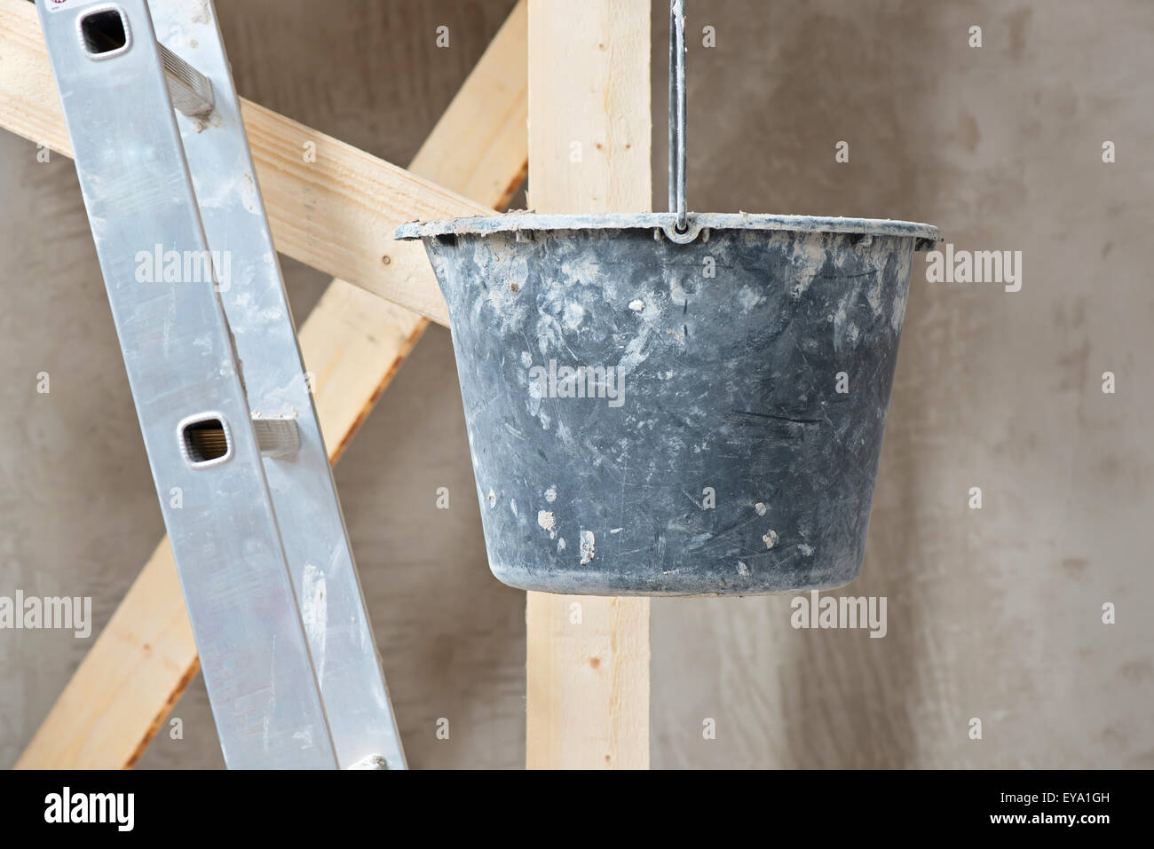 Dirty bucket and ladder on wall background Stock Photo - Alamy